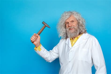 노인 을 입고 의사의 가운 스튜디오 고립 에 푸른 서 와 망치 찾고 카메라 행복 곱슬 머리에 대한 스톡 사진 및 기타 이미지 곱슬 머리 괴짜 기이함 Istock