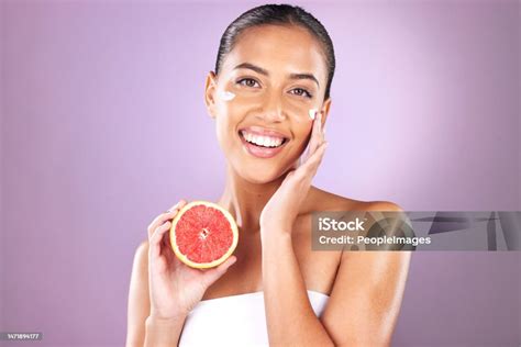 여성 얼굴 스킨케어 또는 자몽 제품은 유기농 피부과 건강 관리 또는 셀프 케어 그루밍을 위한 보라색 스튜디오 배경에 있습니다 초상화 미소 또는 행복한 뷰티 모델과 과일