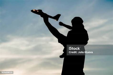 아버지와 아들은 해질녘에 장난감 비행기를 발사합니다 하늘을 배경으로 하는 사람들의 실루엣 친절한 가족과 아버지의 날의 개념 항공 투어 여행 비행 및 휴가를 떠나십시오 2 3