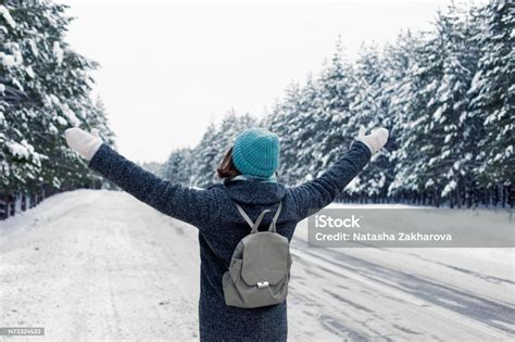 회색 코트를 입은 소녀는 회색 배낭을 뒤로 하고 아름다운 겨울 숲에 서 있습니다 겨울에 대한 스톡 사진 및 기타 이미지 겨울 날씨 눈 냉동상태의 물 Istock