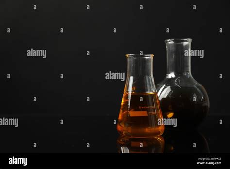 Glass Flasks With Different Types Of Oil On Black Background Space For