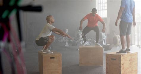 Diverse Group Fitness Class Jumping Onto Boxes Cross Training At Gym