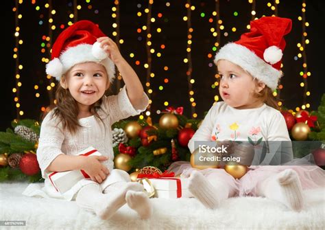 크리스마스 장식 행복한 감정 겨울 휴가 개념 조명과 보케 조명 어두운 배경에 아이 소녀 초상화 2명에 대한 스톡 사진 및 기타 이미지 Istock
