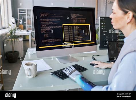 Software Developer With Prosthetic Arm Checking Programming Code On