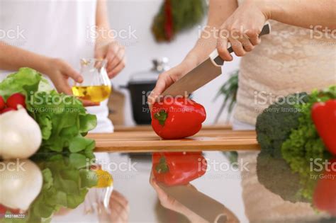 부엌에서 요리 하는 인간의 손에의 근접 촬영 어머니와 딸 또는 신선한 샐러드 야채를 절단 하는 두 여자 친구 건강 한 식사 채식 음식과 라이프 스타일 개념 가까운에 대한