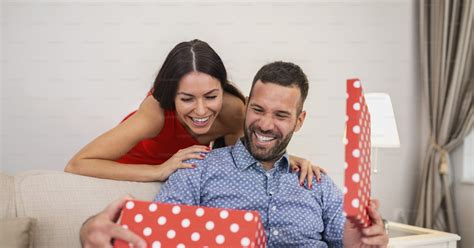발렌타인 데이 또는 기념일에 대한 사랑을 축하하는 아름다운 미소 짓는 젊은 커플 선물로 그를 놀라게 하는 매력적인 여자 사진 Unsplash의 이미지