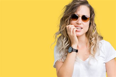 아름 다운 젊은 금발 여자는 스트레스와 입 물고 손톱에 손으로 긴장 찾고 고립 된 배경 위에 선글라스를 입고 불안 문제 감정에 대한 스톡 사진 및 기타 이미지 Istock