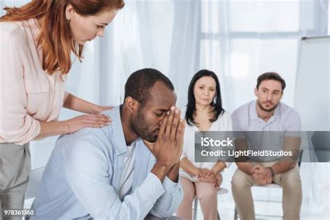 익명 그룹 치료 기간 동안 화가 아프리카계 미국인 남자를 지 원하는 가운데 세 사람 그룹 치료에 대한 스톡 사진 및 기타 이미지 그룹 치료 다민족 그룹 모임 Istock