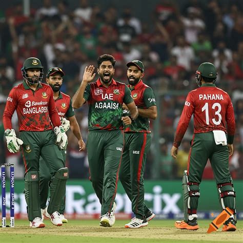 Cricket Players In Red And Green Uniforms Celebrate During A Match In A Stadium On Craiyon