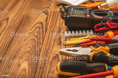 복사 공간이 있는 갈색 배경에 전기 장비 평면도 전기 공구 세트 멀티 미터 테스터 스크루 드라이버 커터 덕트 테이프 램프 줄자 및 와이어 플렛 누워 0명에 대한 스톡 사진