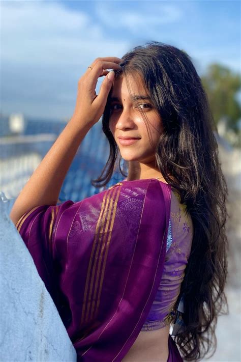 A Beautiful Young Woman In A Purple Sari Posing For The Camera With Her