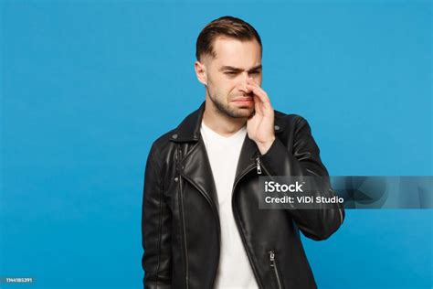 젊은 슬픈 좌절 까만 자 켓 흰색 T셔츠 블루 벽 배경 스튜디오 초상화에 고립 된 카메라를 보고 걱정 하지 않는 남자 사람들은 진심으로 감정 라이프 스타일 개념입니다 복사