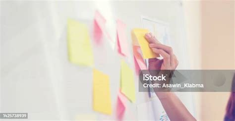 비즈니스 사람들은 사무실에서 만나서 포스트 잇 노트를 사용하여 아이디어를 공유합니다 브레인스토밍 개념 유리 벽에 스티커 메모창조적 인 사무실에서 함께 일하고 의사 소통하는