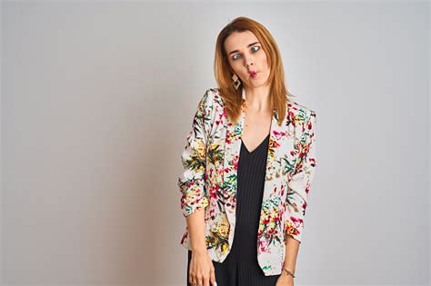 입술 미친 코믹 한 제스처와 물고기 얼굴을 만드는 고립 된 배경 위에 봄 꽃 재킷 정장을 입고 젊은 백인 비즈니스 여성 재미있는