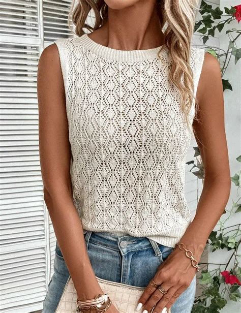 A Woman Wearing A White Top And Jeans With Her Hand On Her Hip Posing For The