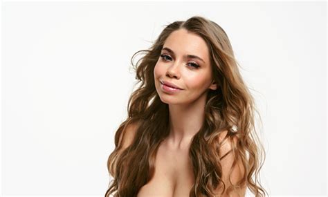 흰색 배경에서 고립 된 젊은 아름다운 여성의 초상화 금발의 소녀 와 길고 빛나는 물결 모양의 머리 곱슬 헤어 스타일과 미소 친절한 소녀 건강관리와 의술에 대한 스톡 사진 및