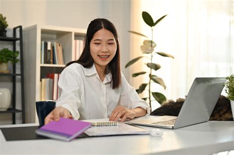 밀레니얼 세대의 아시아 여성들이 홈 오피스의 하얀 책상에 노트북을 사용하고 있다 기술 프리랜서 및 원격 작업 개념입니다 25