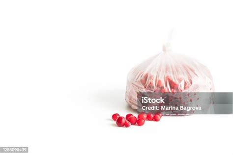 흰색 배경에 고립 된 비닐 봉지에 얼어 붙은 빨간 크랜베리 열매 냉동 식품의 저장 공간을 복사합니다 가방에 대한 스톡 사진 및