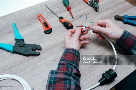 남성 전기 기술자가 전선의 플러그를 바꿉니다 전기 공구 작업 스트리퍼 크림프 스크루 드라이버 와이어 커터 전선을 연결하는 전기 기술자 전기 연료 및 전력 생산에 대한 스톡