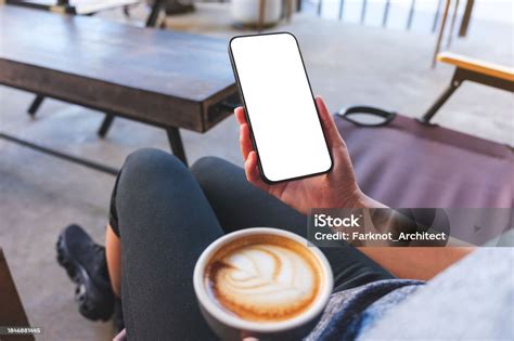 카페에서 커피를 마시면서 빈 데스크톱 화면으로 휴대 전화를 들고있는 여성의 모형 이미지 35 39세에 대한 스톡 사진 및 기타 이미지 35 39세 Brand Name