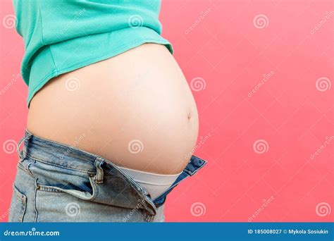 Close Up Of Pregnant Belly At Colorful Background With Copy Space Future Mother In Opened Jeans