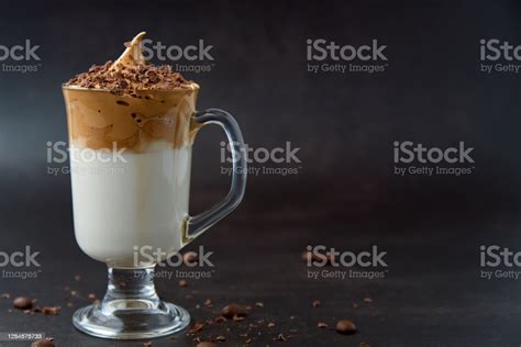트렌디한 푹신한 크림 달고나 또는 어두운 배경에 우유 커피 콩 초콜릿을 곁들인 인스턴트 커피 한 잔 새로운 인기 있는 음식 및 음료 트렌드 컨셉 복사 공간â 0명에 대한