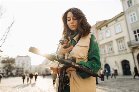 스마트 폰을 사용하여 전기 스쿠터를 임대하는 젊은 여성 전기 스쿠터에 대한 스톡 사진 및 기타 이미지 전기 스쿠터 한 명의