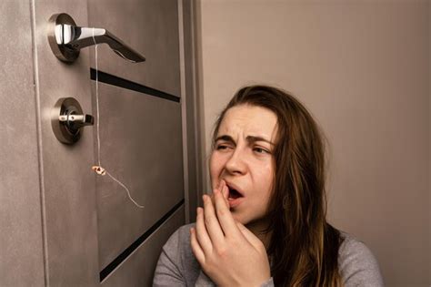 Premium Photo The Girl Is Holding A Thread To Pull Out A Tooth Extraction Of A Tooth In An