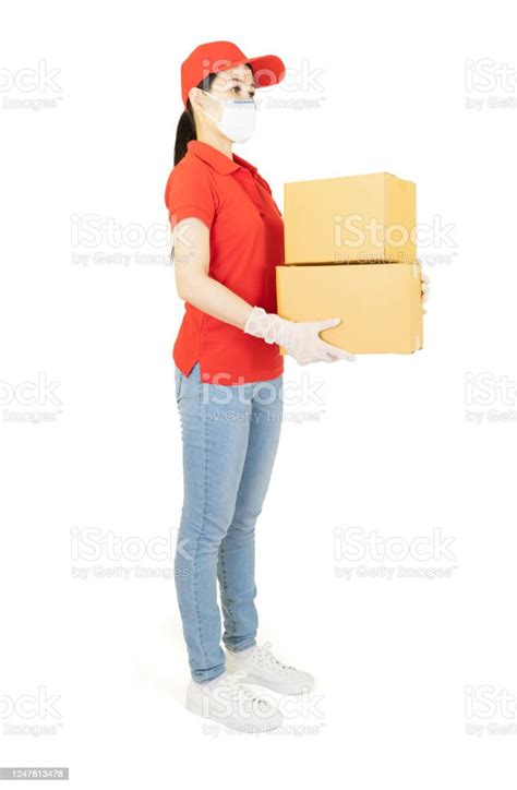 흰색 배경에 고립 된 빨간색 유니폼을 입은 배달 여성 골판지 상자를 들고 보호 마스크와 의료 장갑에 택배 검역 질병 발병에 따른