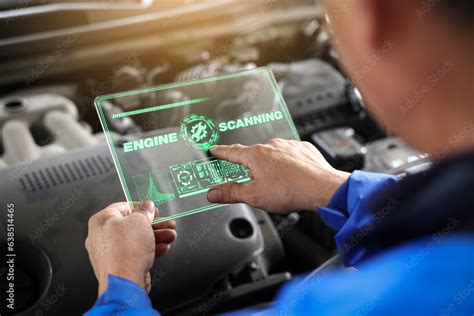 카센터에서 정비공이 투명 태블릿 스크린 홀로그램으로 표시된 진단 결과를 보며 자동차 엔진 상태를 점검하는 모습 Stock Foto Adobe Stock