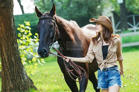 草地上快乐的青年女人牵着马高清图片下载 正版图片507676424 摄图网