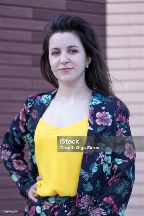 매력적인 젊은 갈색 머리 여자 에 노란색 티셔츠와 꽃 반바지 의상 갈색 벽 배경 복사 공간을 복사합니다 20 29세에 대한 스톡 사진 및 기타 이미지 Istock