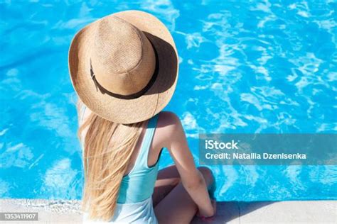 파란색 수영복과 수영장 에 앉아 베이지 색 밀짚 모자를 입고 금발 슬림 소녀 수영장 스포츠 경기장에 대한 스톡 사진 및 기타 이미지 수영장 스포츠 경기장 관광 리조트