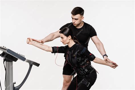 Premium Photo Trainer Shows An Example Of The Exercise Using Ems
