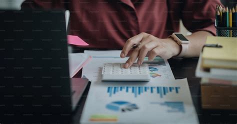 사무실에서 재무 보고서를 계산하기 위해 계산기를 사용하여 책상에서 일하는 회계사 사진 Unsplash의 태국 이미지