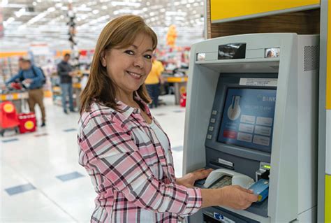 카메라 미소를 직면 하면서 Atm에서 돈을 인출 하는 슈퍼마켓에서 성숙한 여자 현금 자동 입출금기에 대한 스톡 사진 및 기타