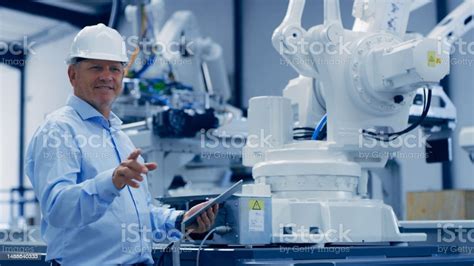 Ai 개발을 위한 자동화의 인간 태블릿 및 로봇 공학 또는 창고의 첨단 기술 공장에서 기계 학습 또는 제어를 위해 기술 및 중장비를 다루는 남성 엔지니어 남자에 대한 스톡