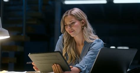 시장 조사를 위한 태블릿을 가진 밤 사무실 및 여성 통계 데이터 또는 보고서를 읽기 위한 온라인 및 앱 근무 초과 근무 또는 고객 정보 및 Swot 분석 검토가 있는 런던