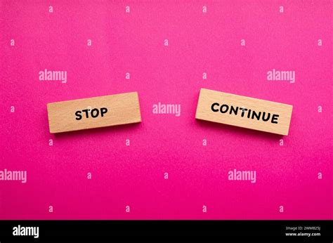 Stop Or Continue Words Written On Wooden Blocks With Pink Background Conceptual Symbol Copy