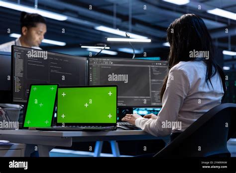 Coworkers In Data Center Using Green Screen Laptop And Tablet To Find Firewall Misconfigurations