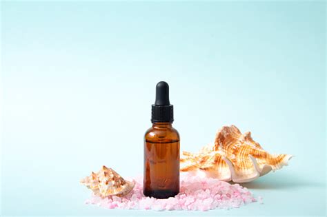 드롭퍼 다크 글래스 화장품 병 모의 분홍색 바다 소금과 파란색 배경에 조개 친환경 케어 유기농 제품 뷰티 트리트먼트 스파 컨셉 공간을 복사합니다 0명에 대한 스톡 사진 및