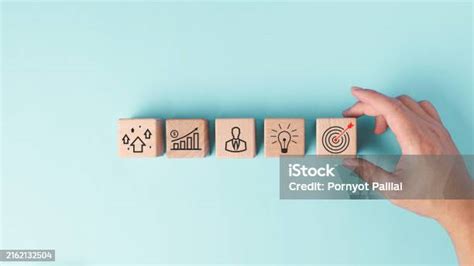 목표 중심점에 빨간색 화살표가 있는 핸드 홀딩 블록은 비즈니스 대상 전략 아이디어 관리 및 성장 목표 개념에서 전구 사업가 그래프 및 화살표와 정렬됩니다 개념에 대한 스톡