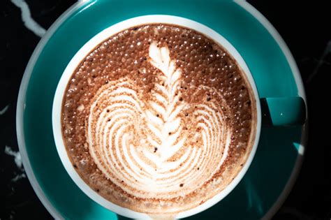 복사 공간이 있는 커피 숍에서 나무 테이블에 라 떼 아트 거품 커피 컵 커피는 가장 인기 있는 음료 중 하나입니다 에너지 레벨을