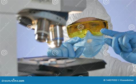 Close Up Shot Of A Scientist Looking At A Glass Slide With Bacteria