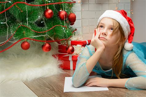 귀여운 소녀는 벽난로 근처에 크리스마스 트리 산타 클로스에 게 편지를 씁니다 개념에 대한 스톡 사진 및 기타 이미지 개념 겨울 귀여운 Istock