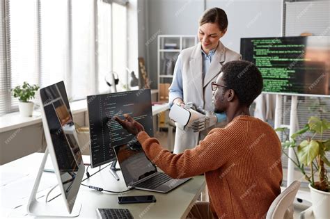 Premium Photo Software Developers Discussing Programming Code When Working On New Application