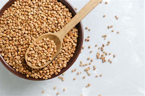 회색 배경에 나무 숟가락이 있는 갈색 그릇에 유기농 건조 메밀 가루 채식주의자 및 비건 음식 건강한 식생활의 개념 수평 방향 평면도 공간을 복사합니다 0명에 대한 스톡 사진