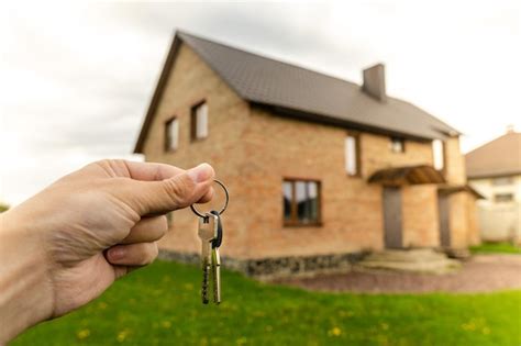 Holding The House Keys In Front Of New Home Premium Photo