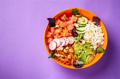 하와이 샐러드 연어 생선 아보카도 한국 당근 오이 무 쌀 검은 참 깨와 고추 오렌지 플레이트 에 2018의 보라색 추세 배경 복사 공간 평면도 슬라이스에 대한 스톡 사진 및