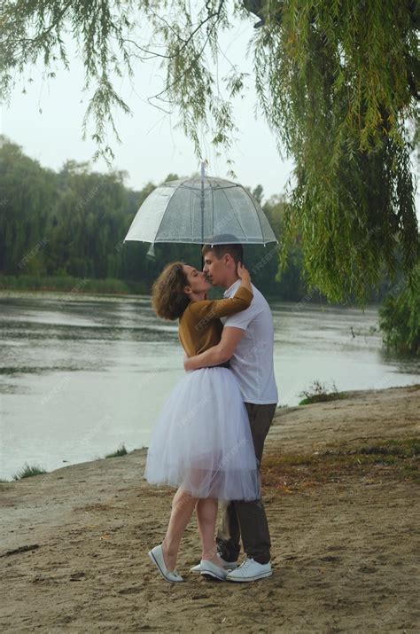 Premium Photo Love Story Couple Walking Near River In Rainfall